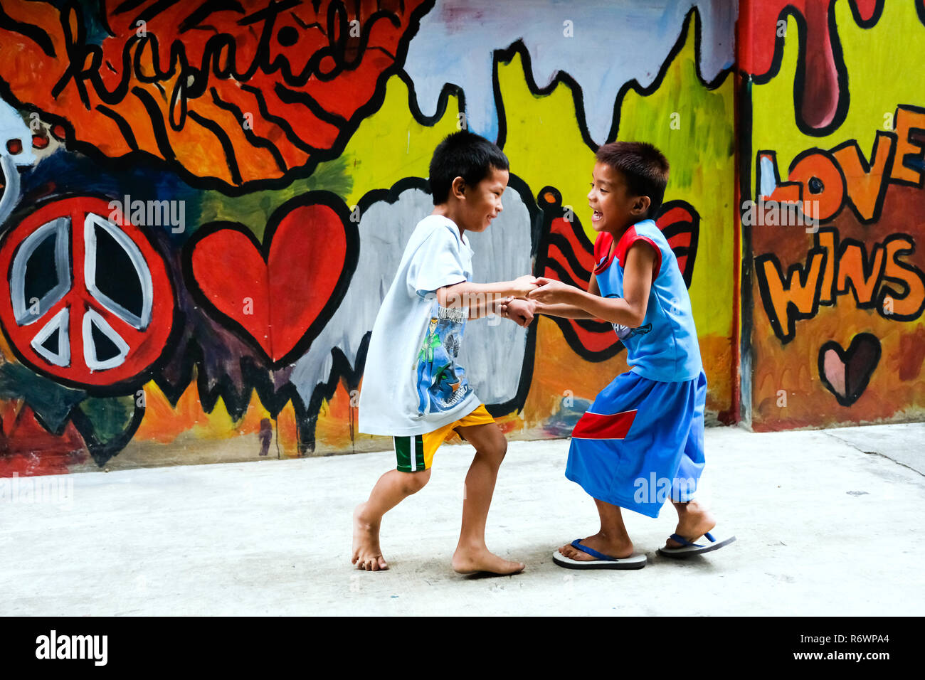 Street kids children are spinning in front of a graffiti wall at the ...