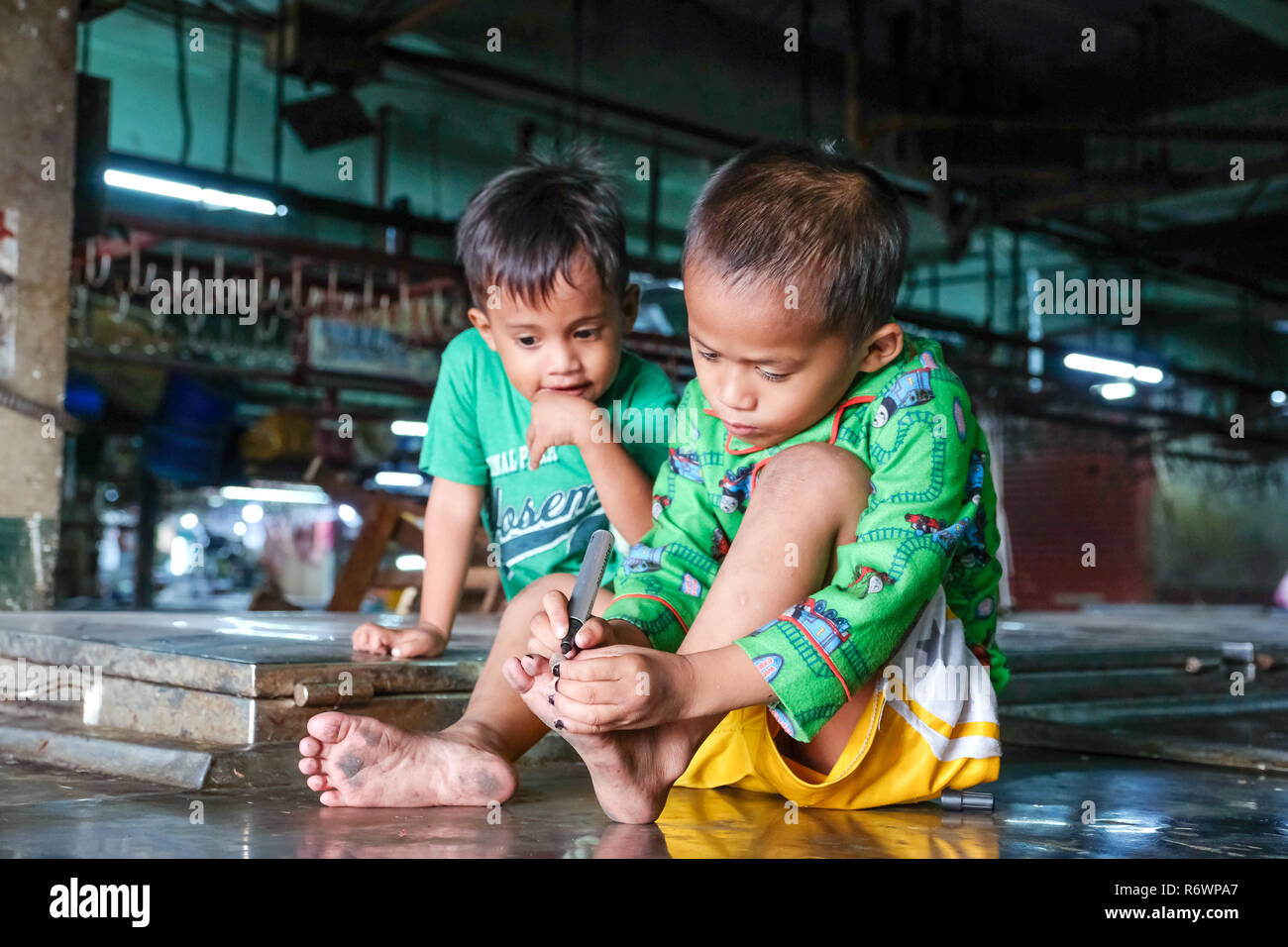 Two street kids at a fish market in Quezon City, Metro Manila ...