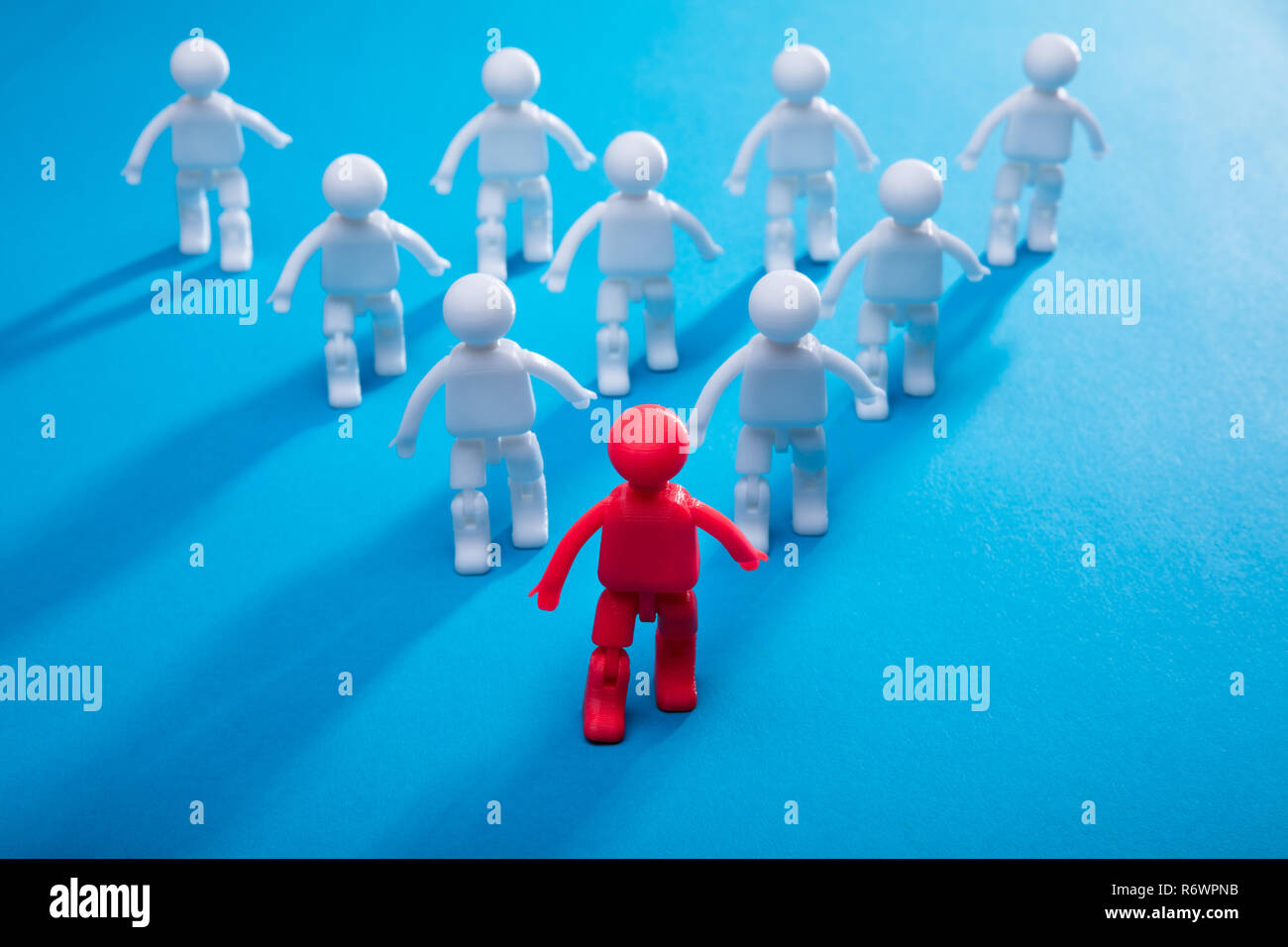 Red Human Figure Leading Team Toward Success Stock Photo - Alamy