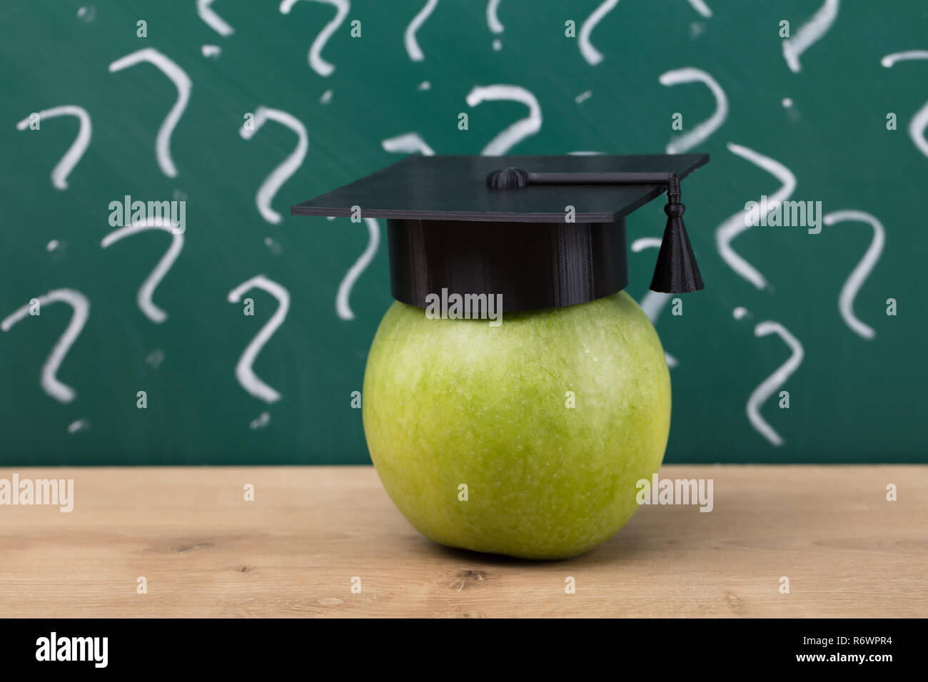 Green Apple With Graduation Hat On Wooden Desk Stock Photo - Alamy