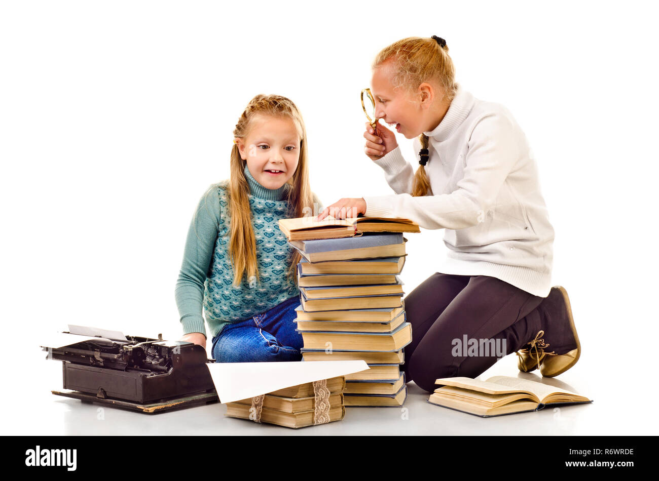 two little girls with a lot of books isolated on a white background ...