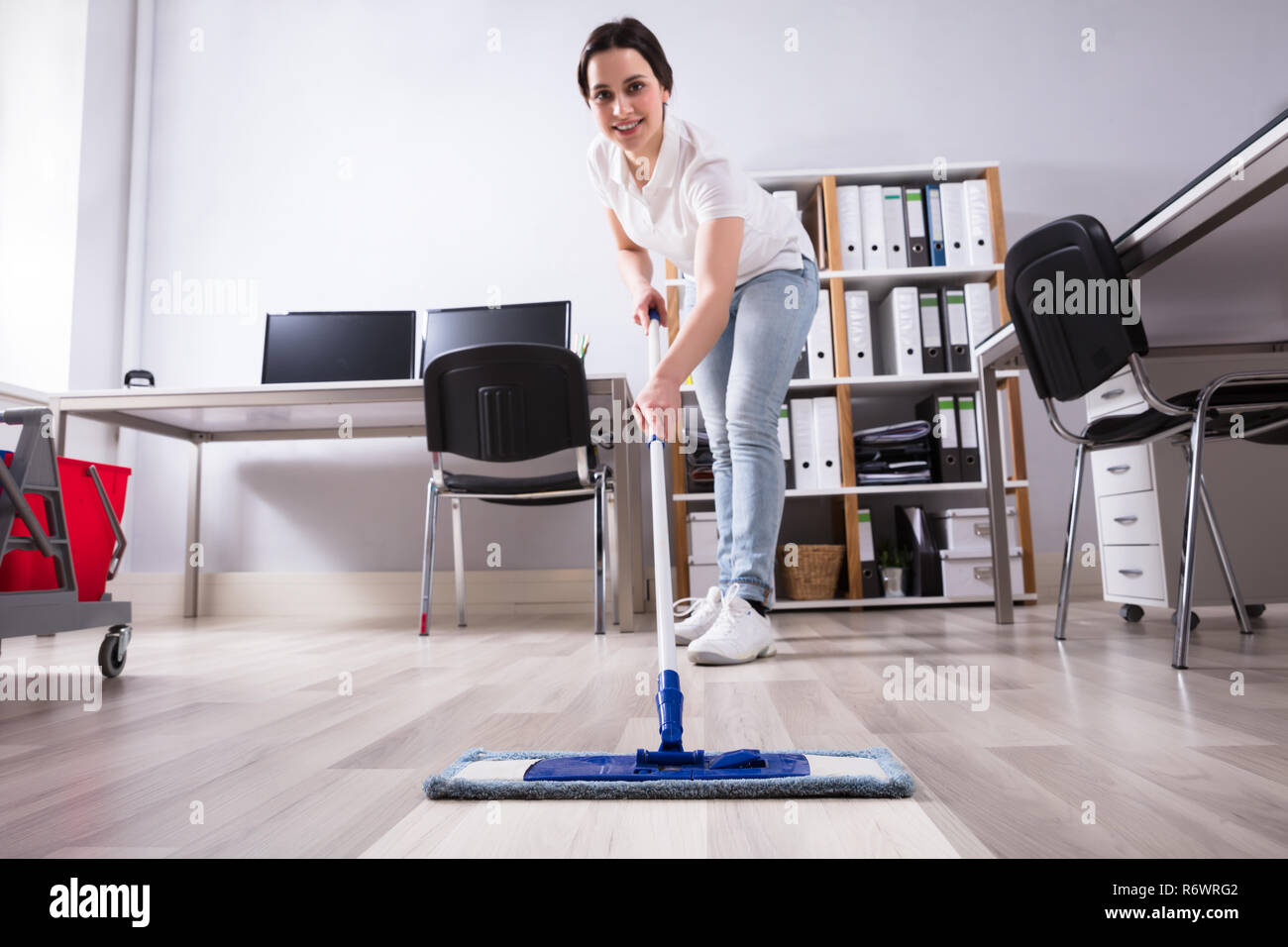 Female Janitor Cleaning Floor In Office Stock Photo - Alamy