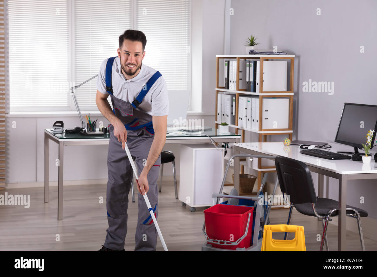 Smiling Male Janitor Cleaning Floor Stock Photo - Alamy