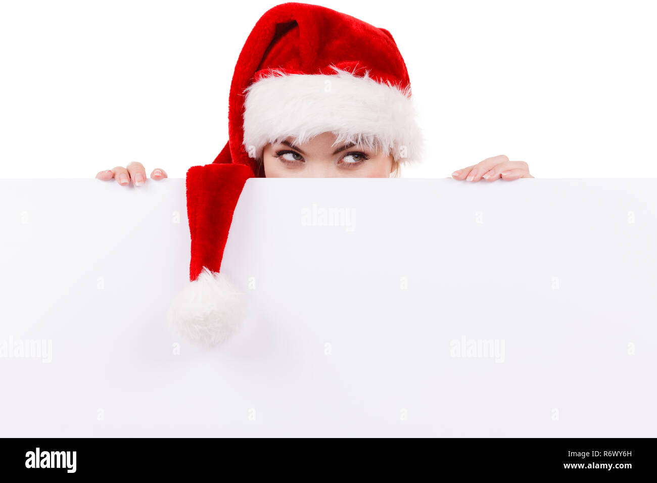 Woman holding banner sign peeking over edge of blank empty billboard ...