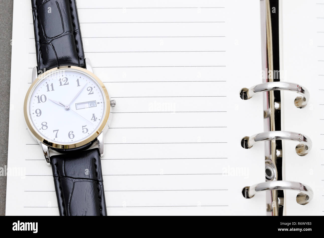 wrist watch with leather strap on business notebook Stock Photo - Alamy
