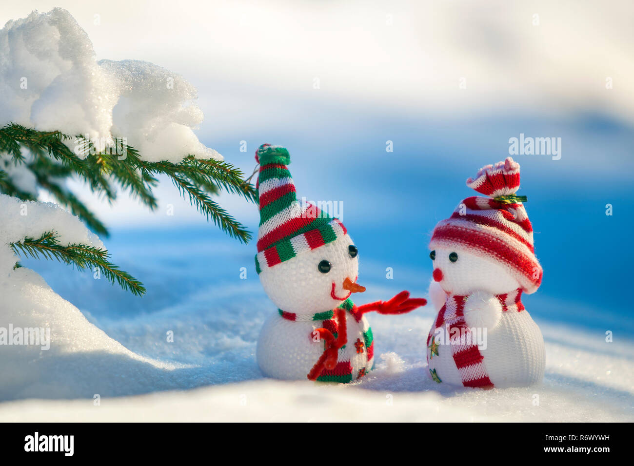 Two small funny toys baby snowman in knitted hats and scarves in deep ...
