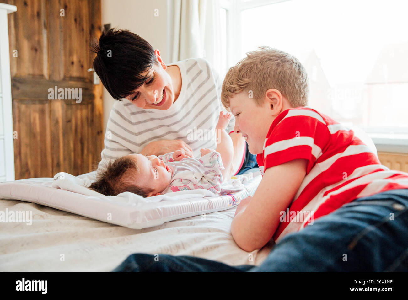 Helping Mum with the Baby Stock Photo - Alamy