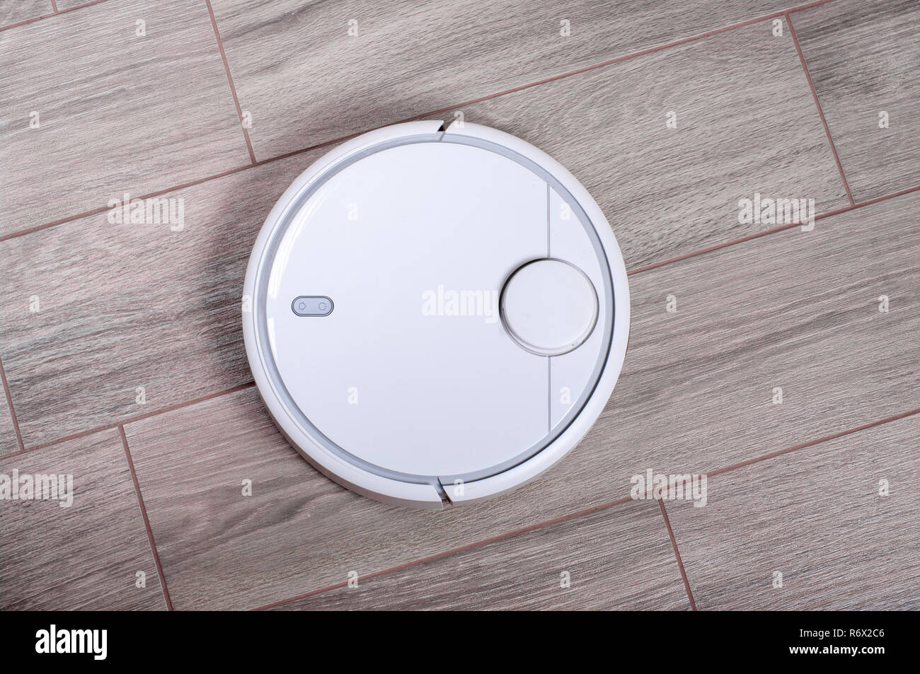 automated robot vacuum cleaner on tile floor. smart robotic automate ...