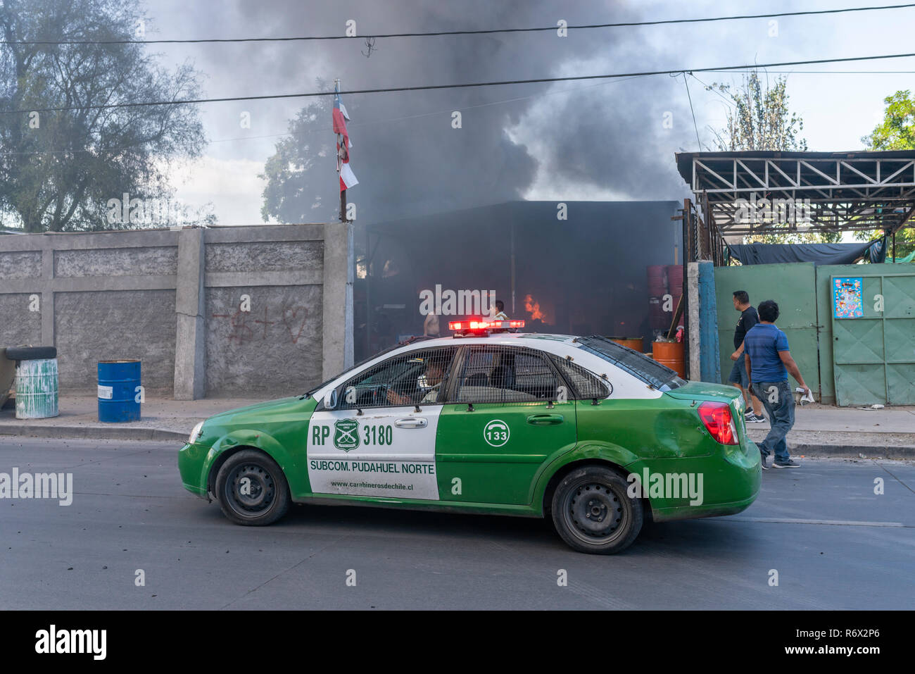 Police car stopped in front of a fire inside a workshop in Pudahuel ...