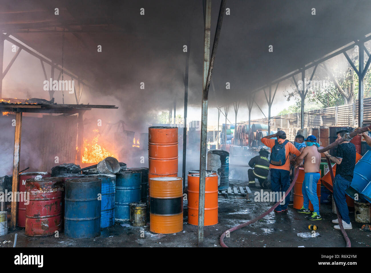 Firefighters and people fighting a fire inside a workshop in Pudahuel ...