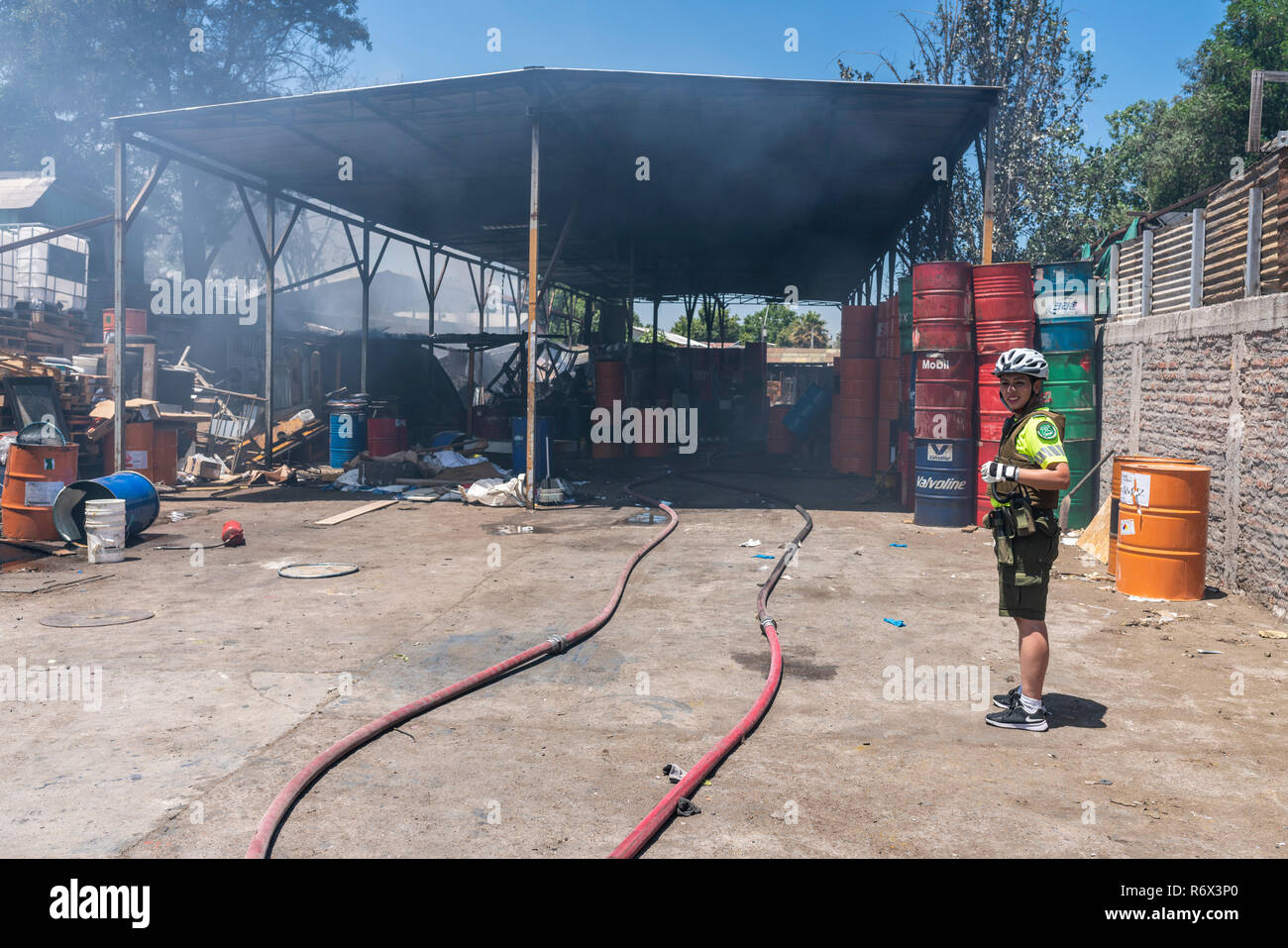 Firefighters and people fighting a fire inside a workshop in Pudahuel neighborhood at Santiago ...