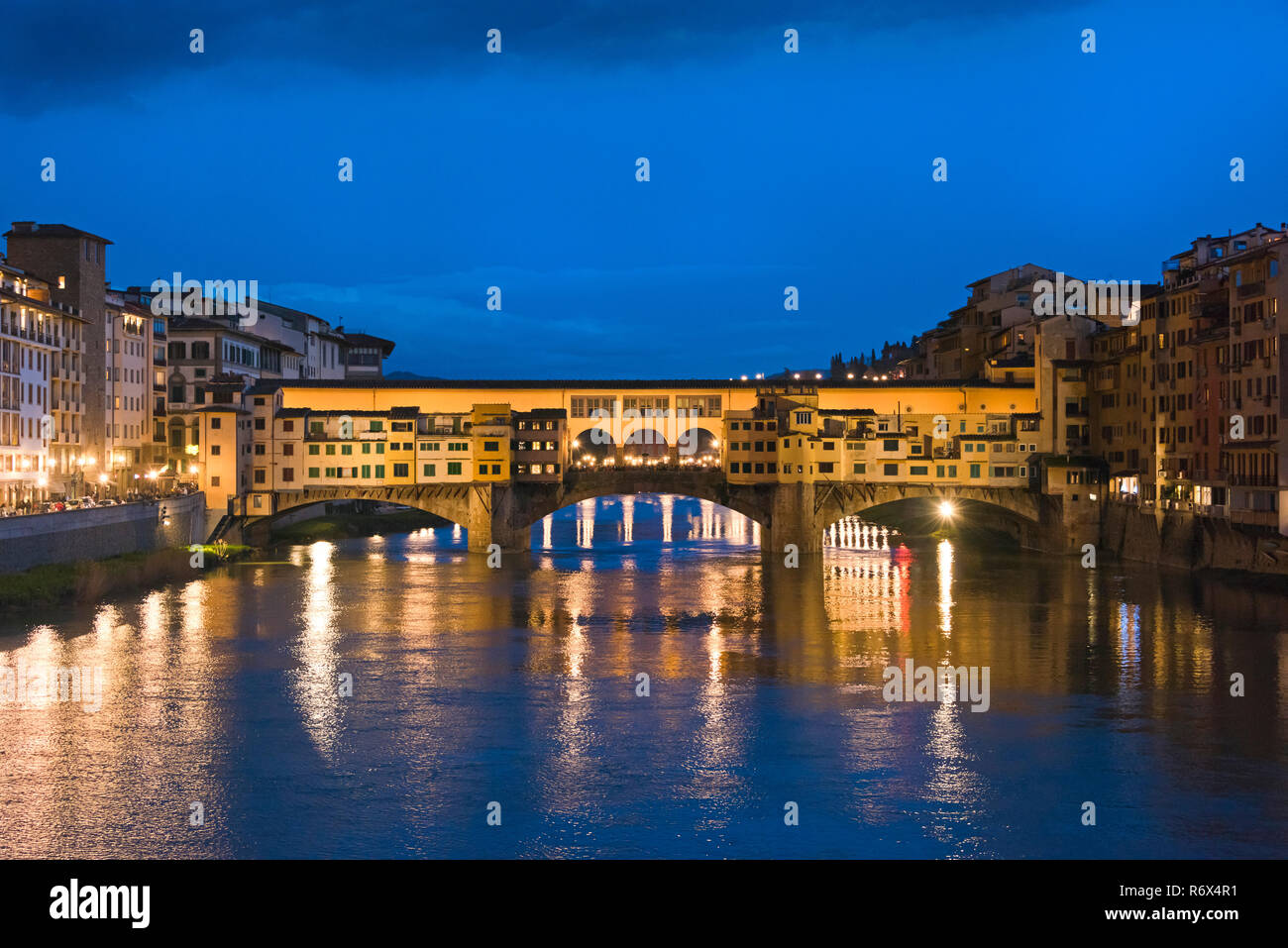 Horizontal panoramic view of the Ponte Vecchio lit up at night in ...