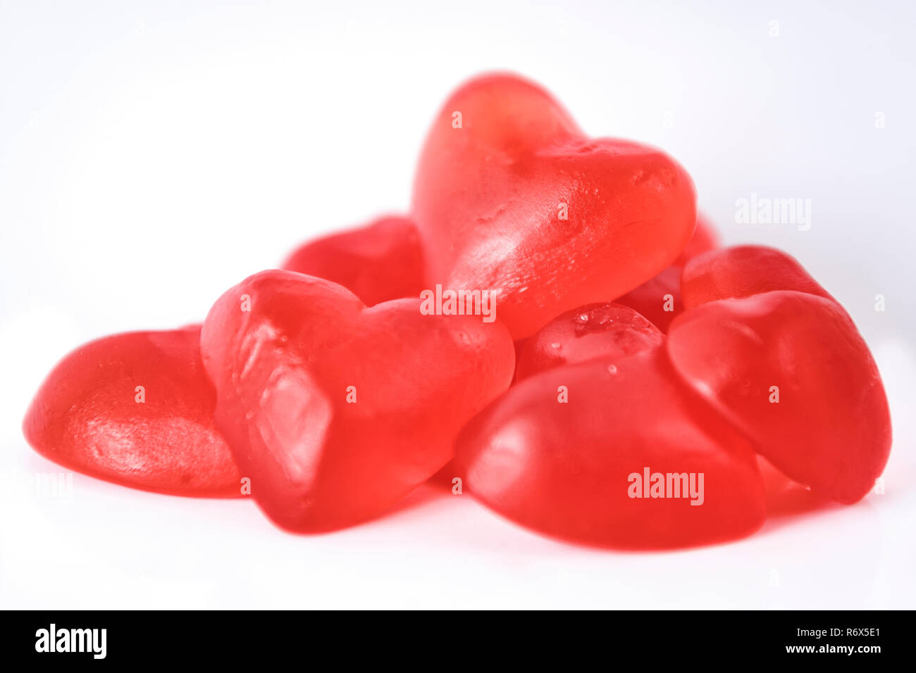 Handful of bright red jelly heart shaped sweets isolated on white ...