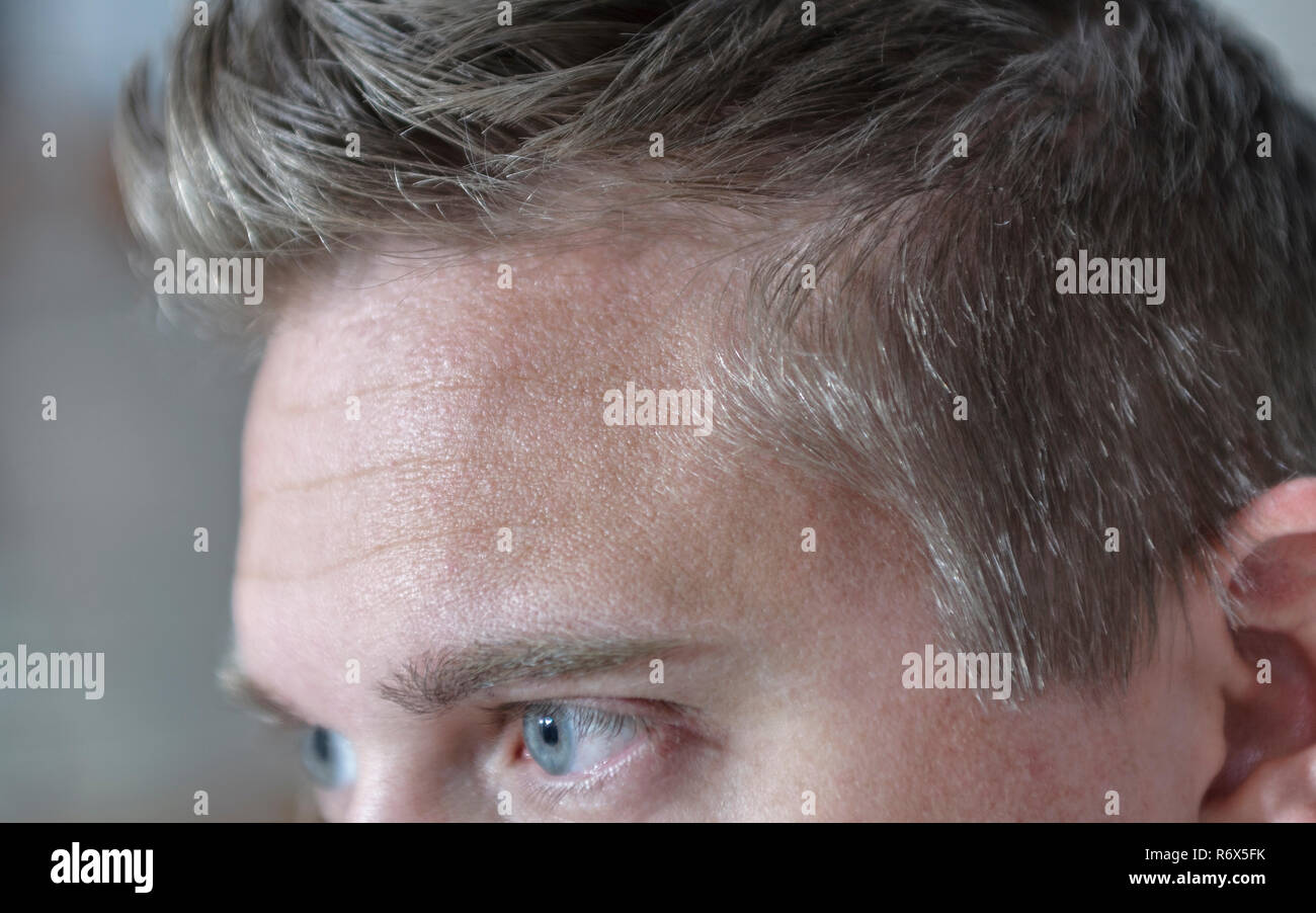 Close up sideview of adult man face and head with focus on his blue ...