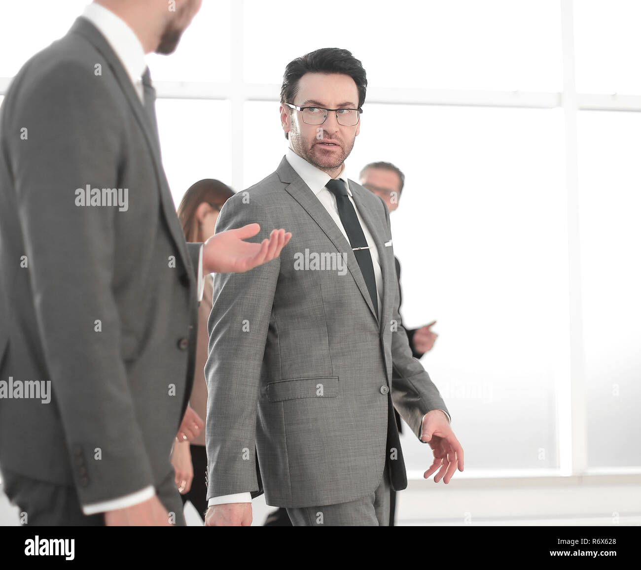 Two businesspeople walking in corridor talking Stock Photo - Alamy