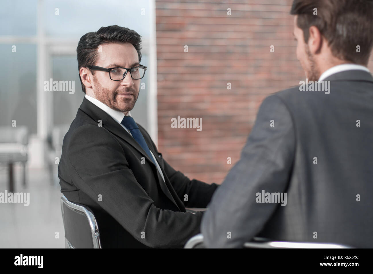 rear view.two businessman sitting at his Desk Stock Photo - Alamy