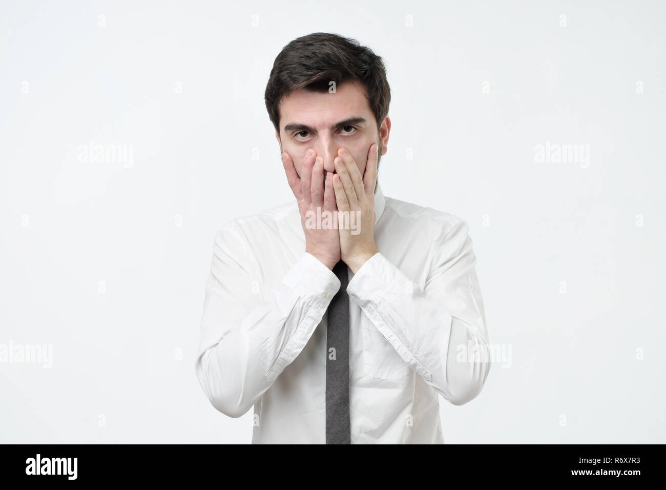 Mature annoyed spanish man pulling skin on face with hands. He is ...