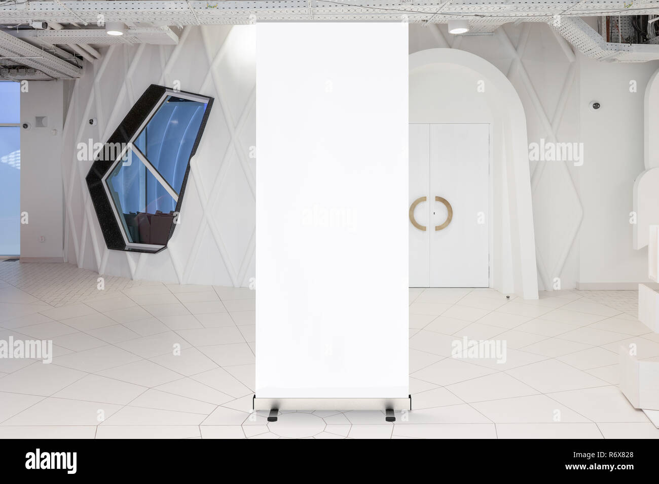 Blank roll up banner stand in contemporary office lobby interior with ...