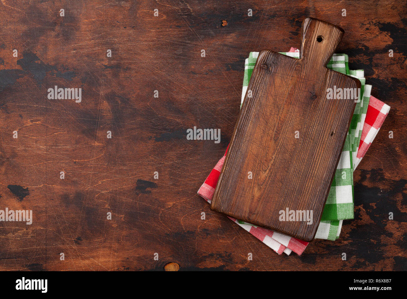 Cooking wooden table with cutting board over kitchen towel or napkin ...