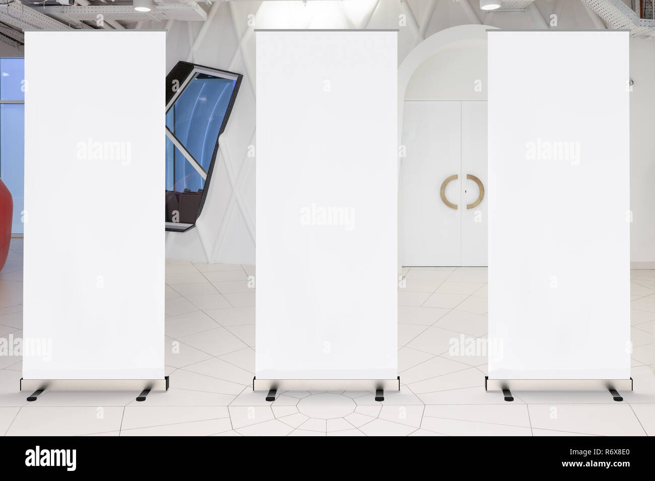 Three blank roll up banner stand in office lobby interior with clipping ...