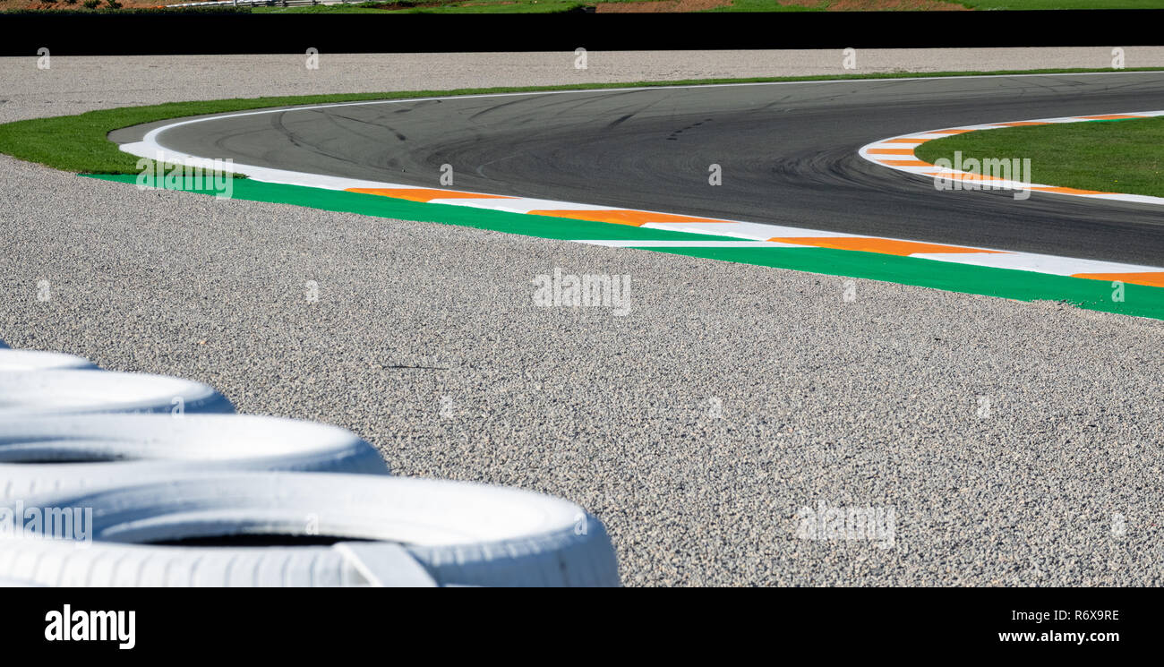 Racing circuit road curve with tyres for protection and orange, green ...