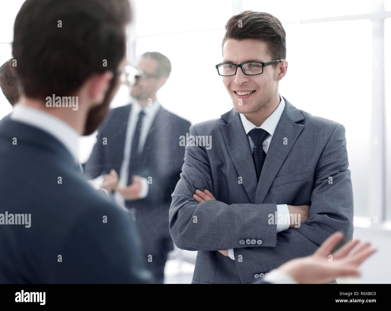 employees talk standing in the office Stock Photo - Alamy