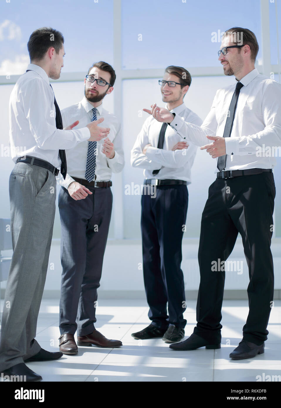 employees discussing their ideas standing in the office lobby Stock ...