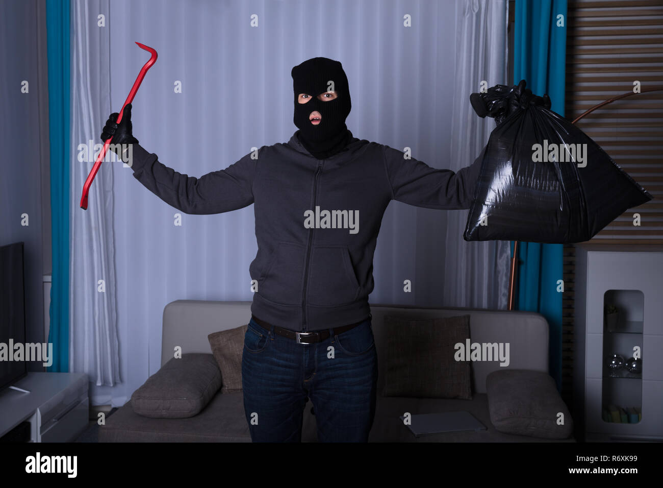 Robber Holding Plastic Bag And Crowbar Stock Photo - Alamy