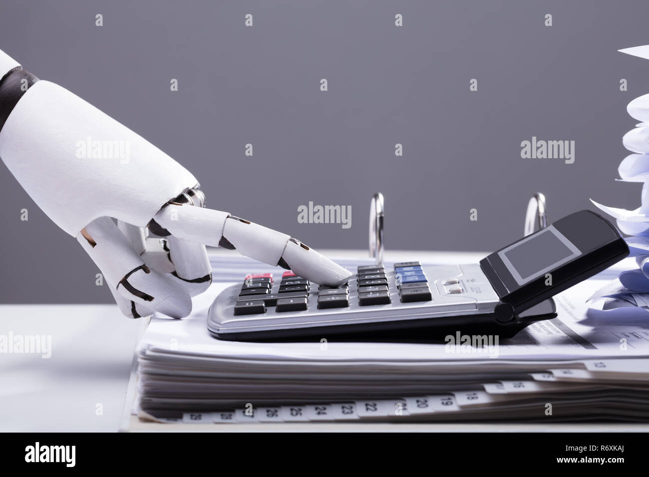 Robotic Hand Using Calculator In Office Stock Photo - Alamy