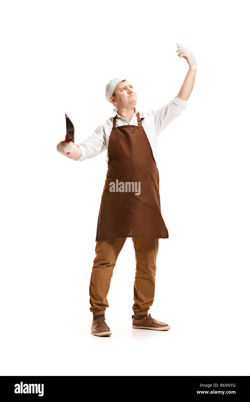Smiling butcher posing with a cleaver isolated on white background ...