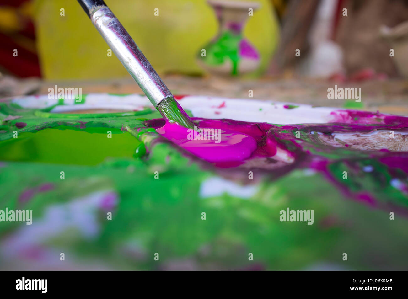 Child loading with purple color her brush Stock Photo - Alamy