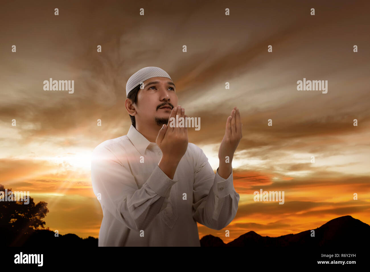 Handsone asian muslim man raising hand and pray Stock Photo - Alamy
