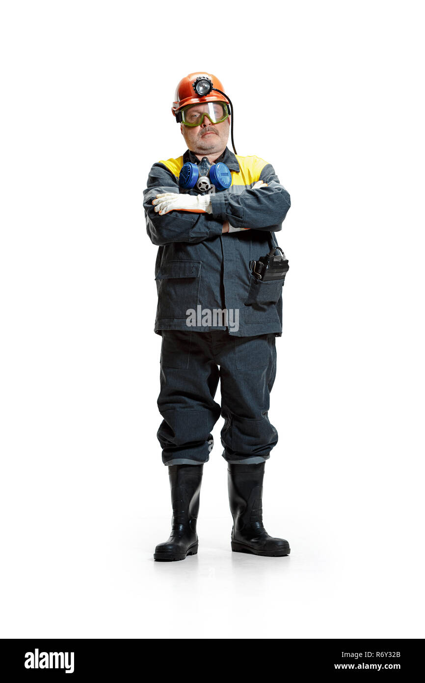 The studio shot of senior bearded male miner standing at the camera on ...