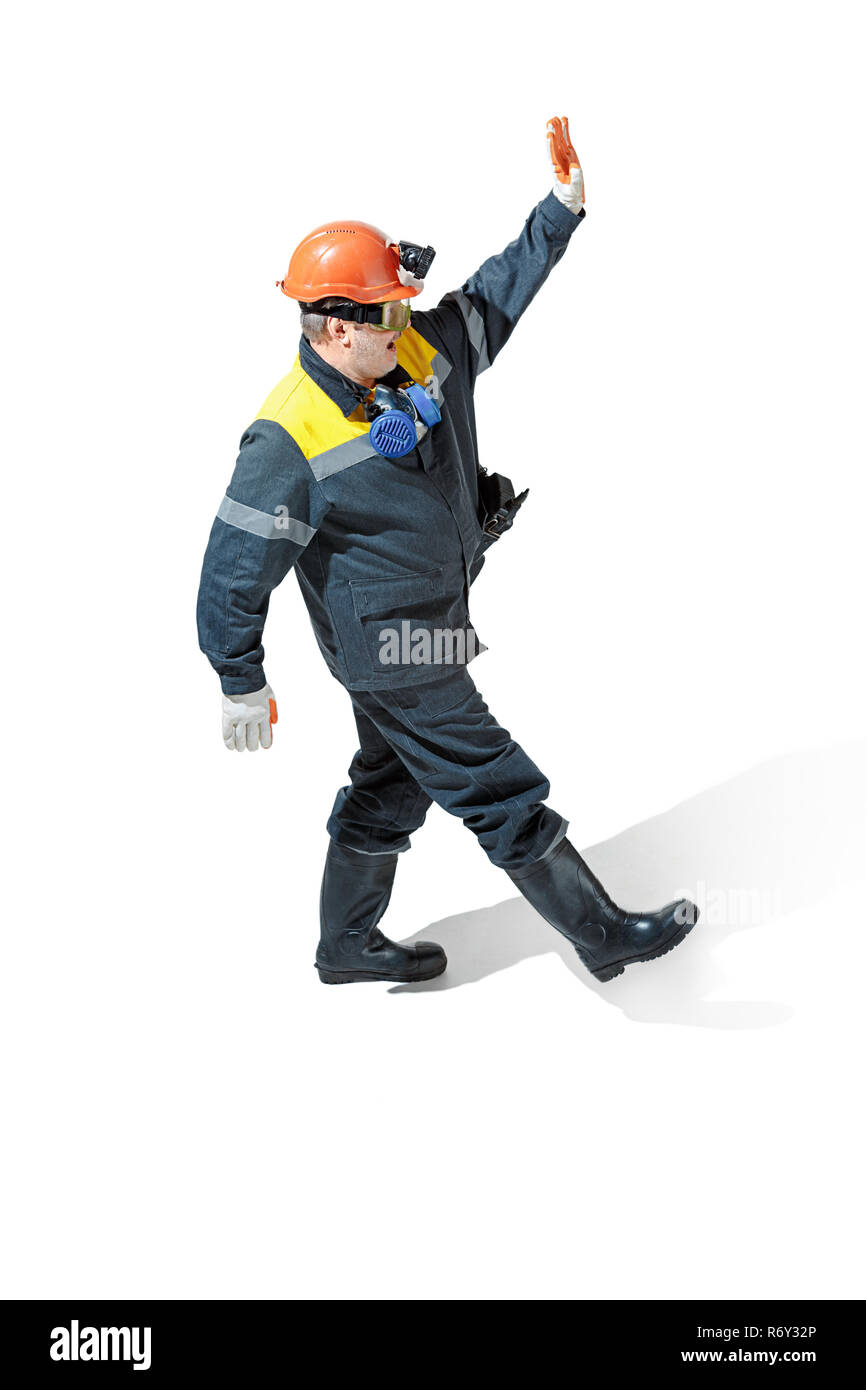 The studio shot of senior bearded male miner standing at the camera on ...