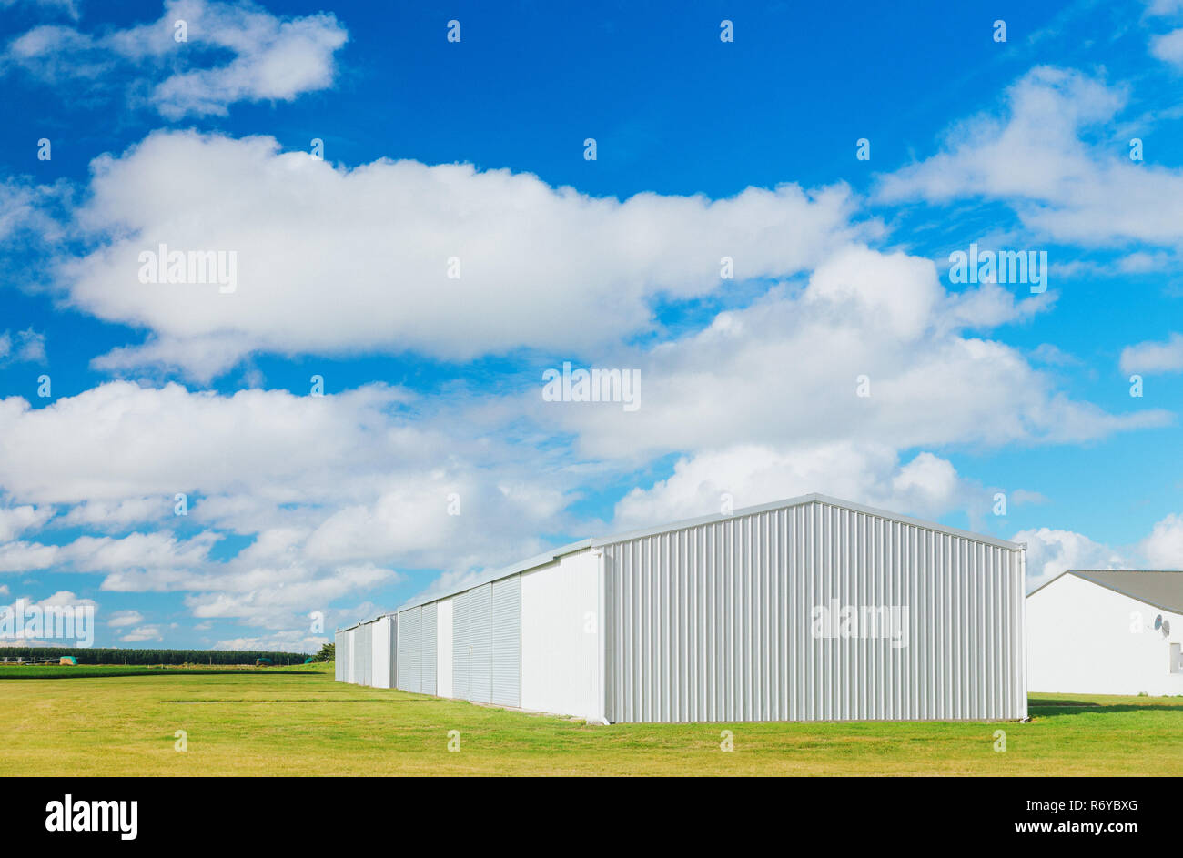 Metallic warehouse with blue sky Stock Photo - Alamy