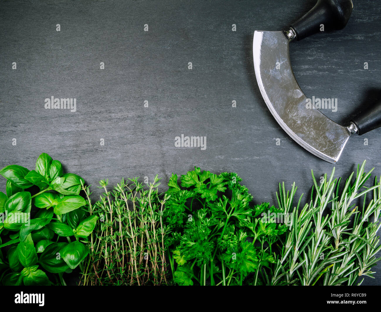 Herbs and cutter on slate background Stock Photo - Alamy