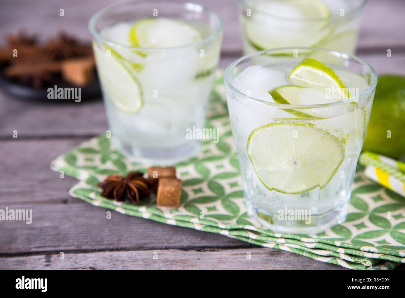 homemade lemonade with lime, anise, cinnamon and ice on a wooden ...