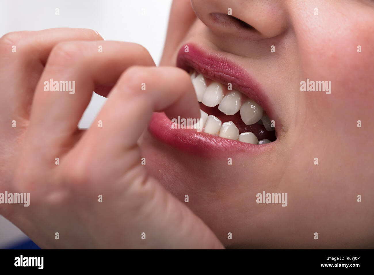 Businesswoman Biting Her Fingernail Stock Photo - Alamy