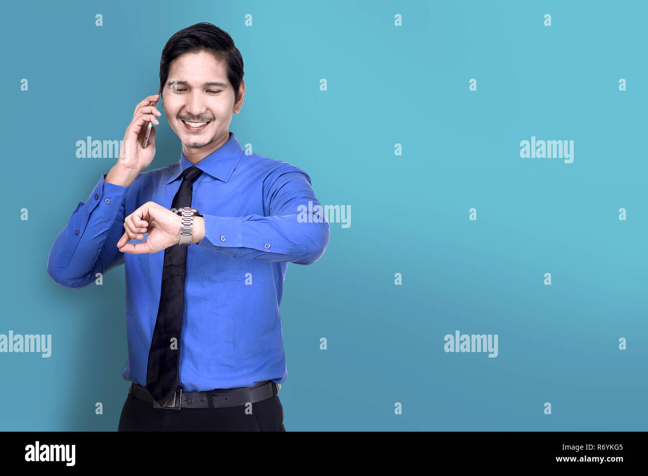 Smiling asian businessman check the watch while talking on phone Stock ...