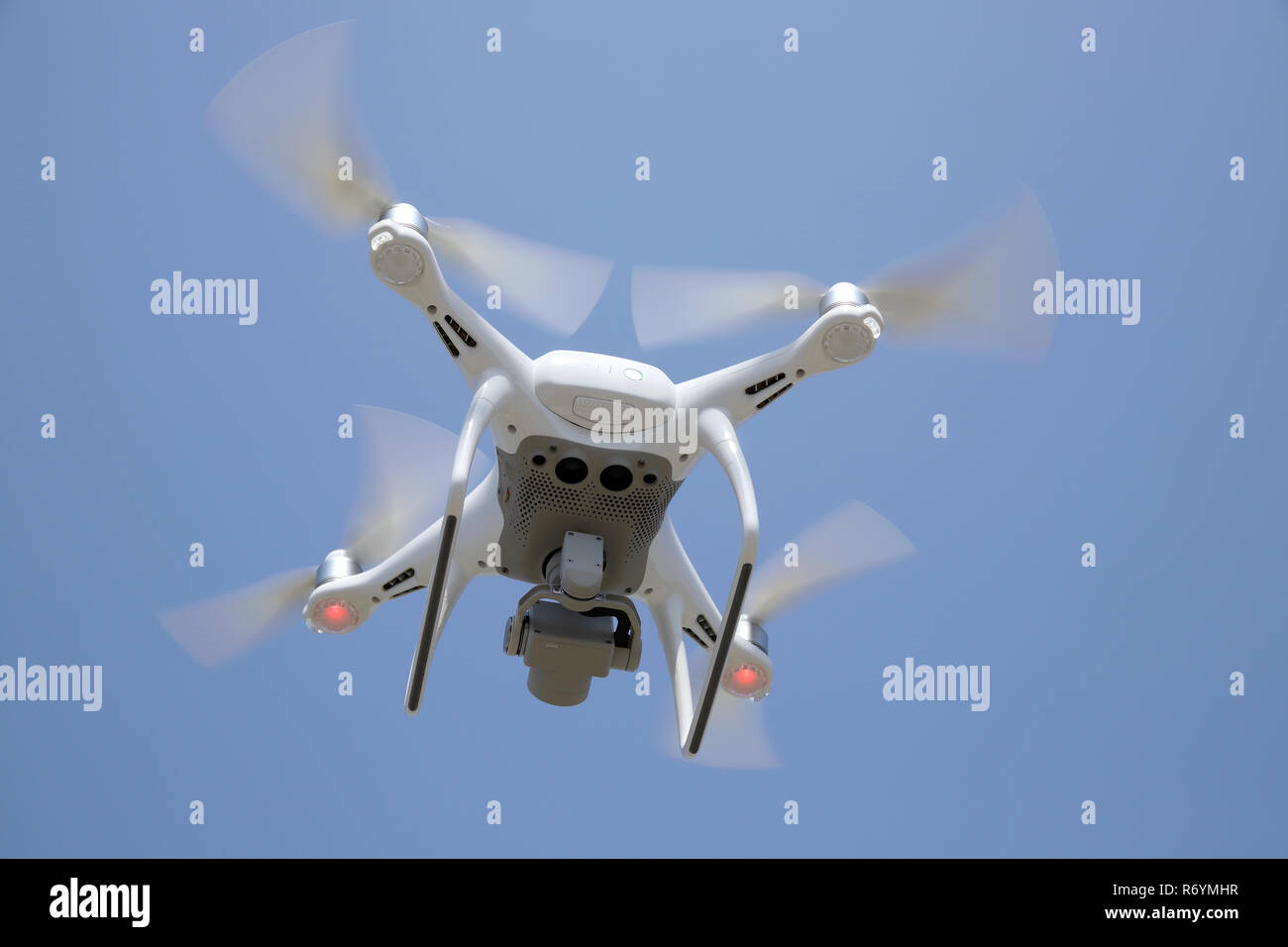White drone flying in air and clear blue sky background Stock Photo - Alamy
