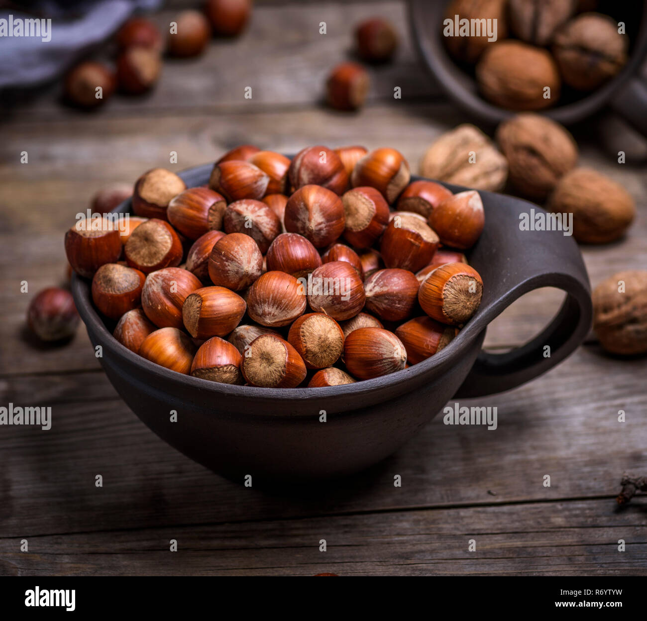 hazelnut in a shell in a brown clay cup Stock Photo - Alamy