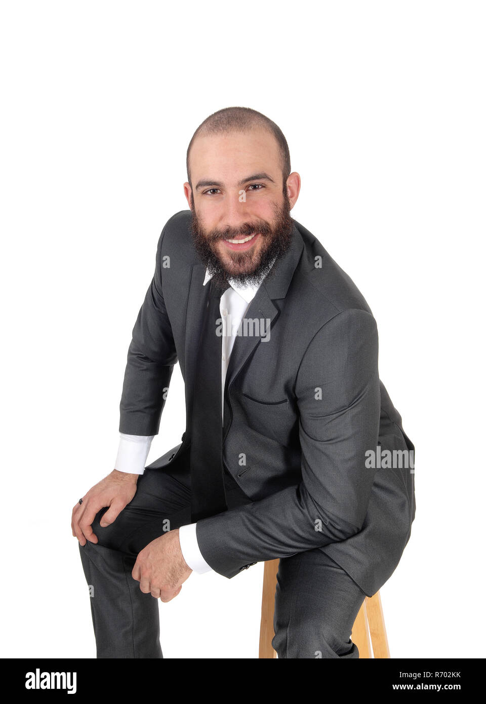Business man sitting, bending forward, smiling Stock Photo - Alamy