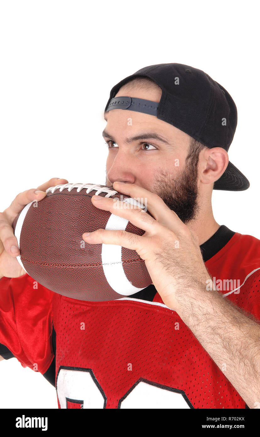 Football player holding his ball on his mouth thinking Stock Photo - Alamy