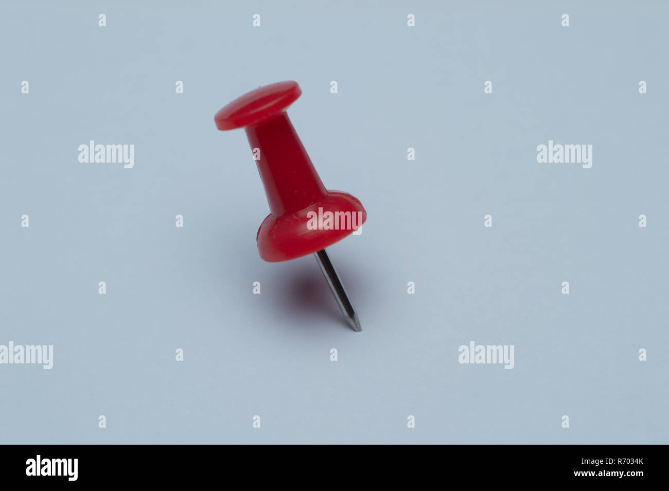 Single red pushpin isolated on white papers Stock Photo - Alamy