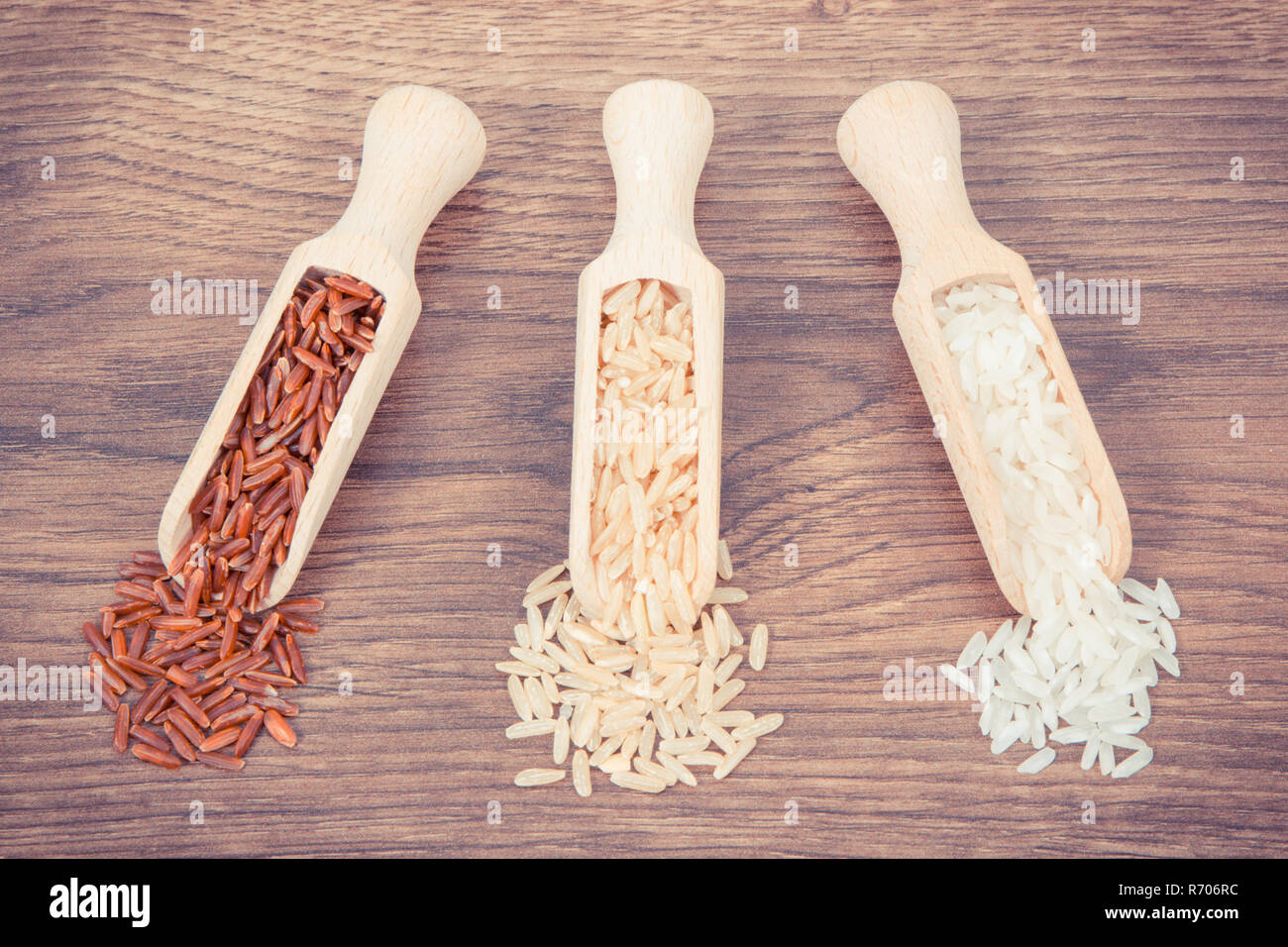Vintage photo, Red, brown and white rice seeds on wooden scoop, concept ...