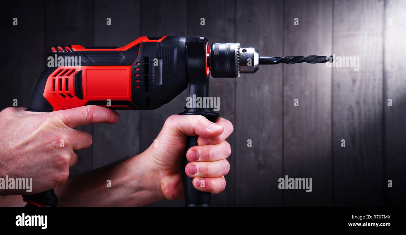 Male hands holding power drill Stock Photo - Alamy