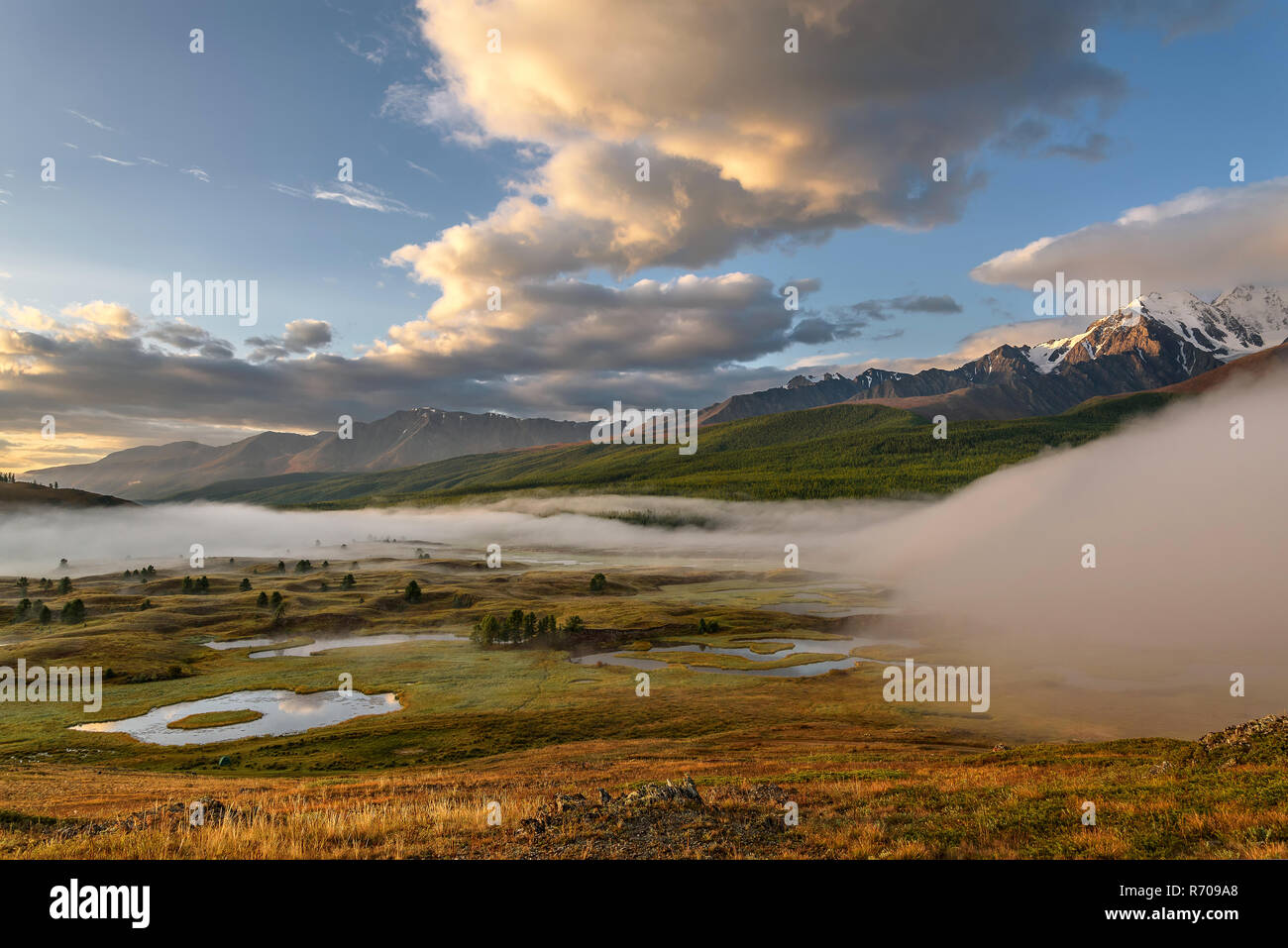 Amazing landscape with golden sunrise over a green valley with lakes ...