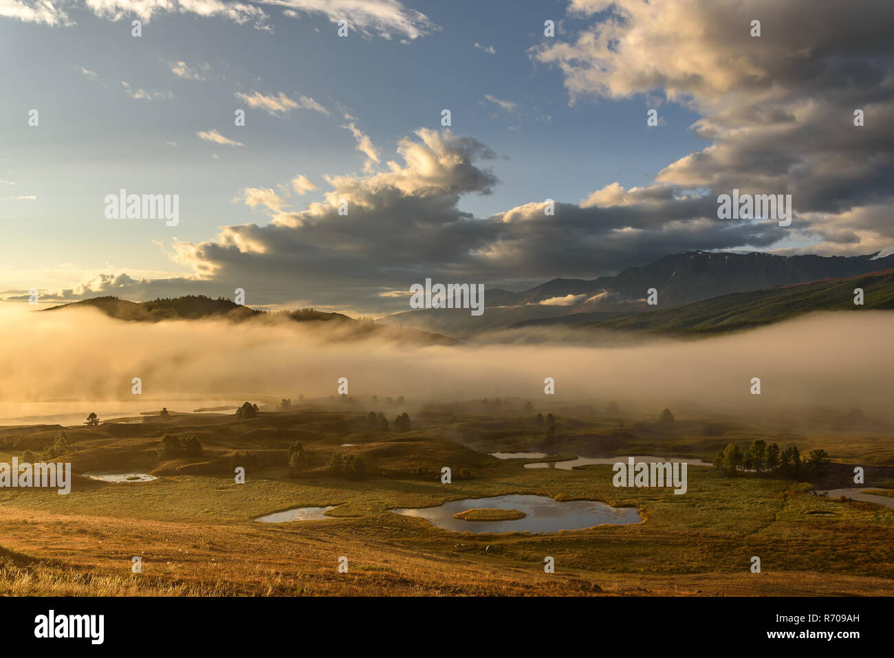 Amazing landscape with golden sunrise over a green valley with lakes ...