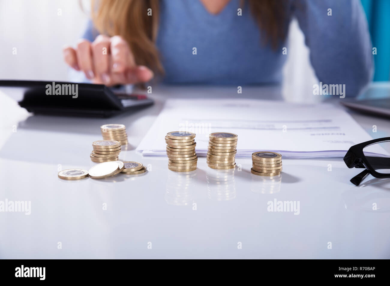Woman Calculating Invoice With Stacked Of Golden Coins On Desk Stock ...