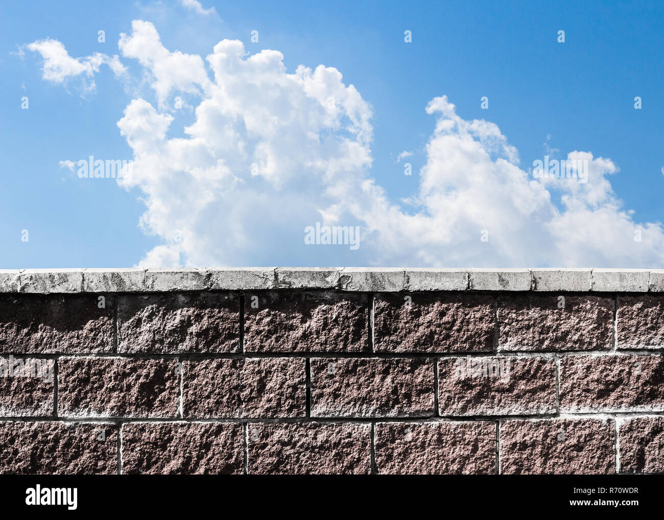 Wall and sky. A dark brick wall against the background of a light sky ...